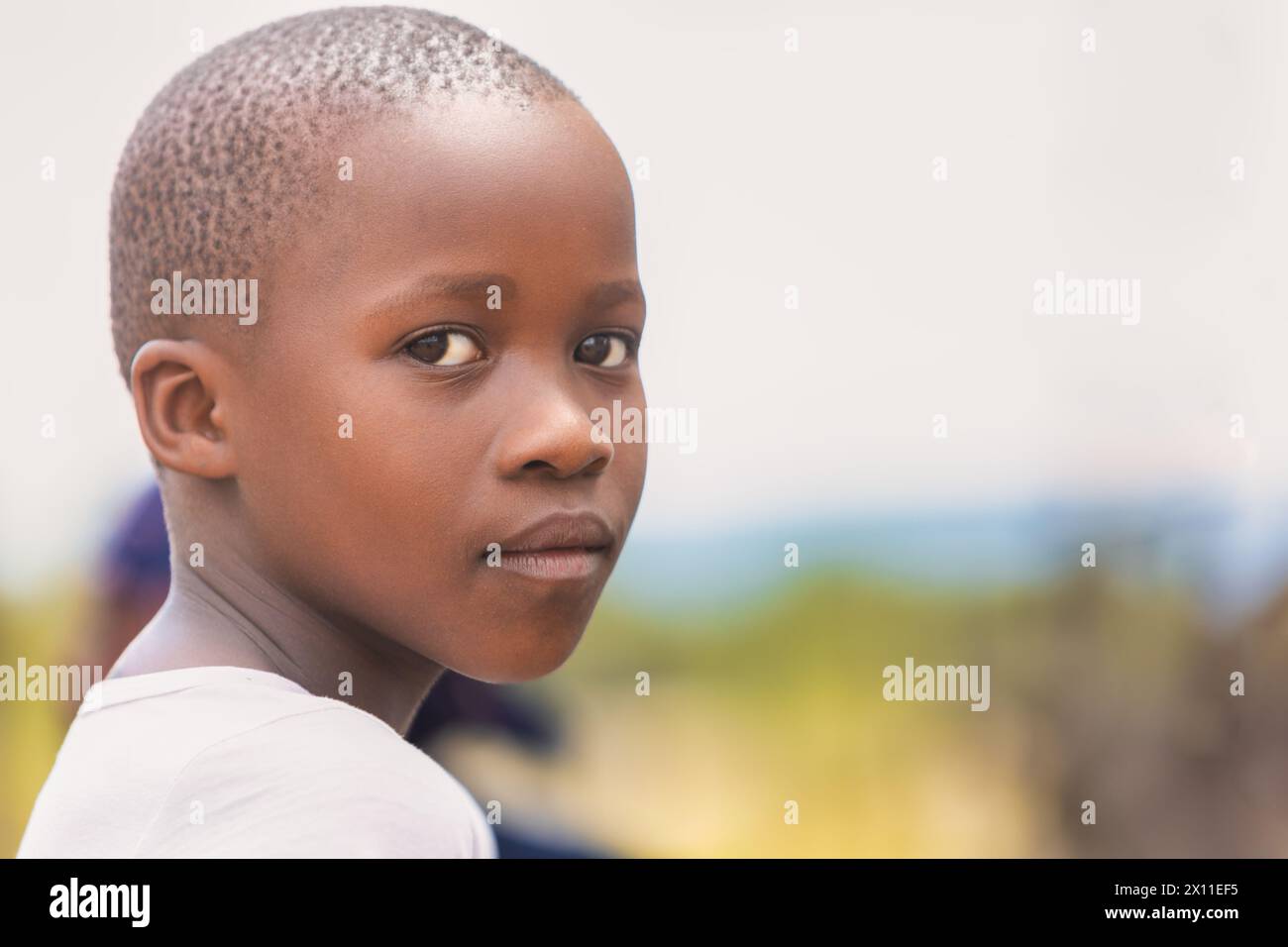 portrait of happy african child with a smile, outdoors in the village ...