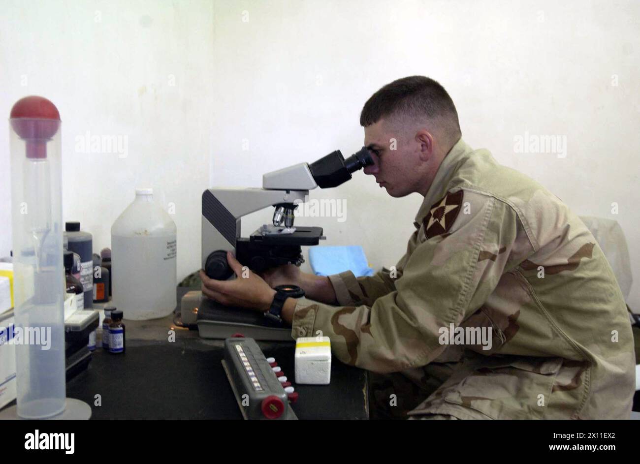 Spc. Matty Whipple looks through his microscope to determine whether ...