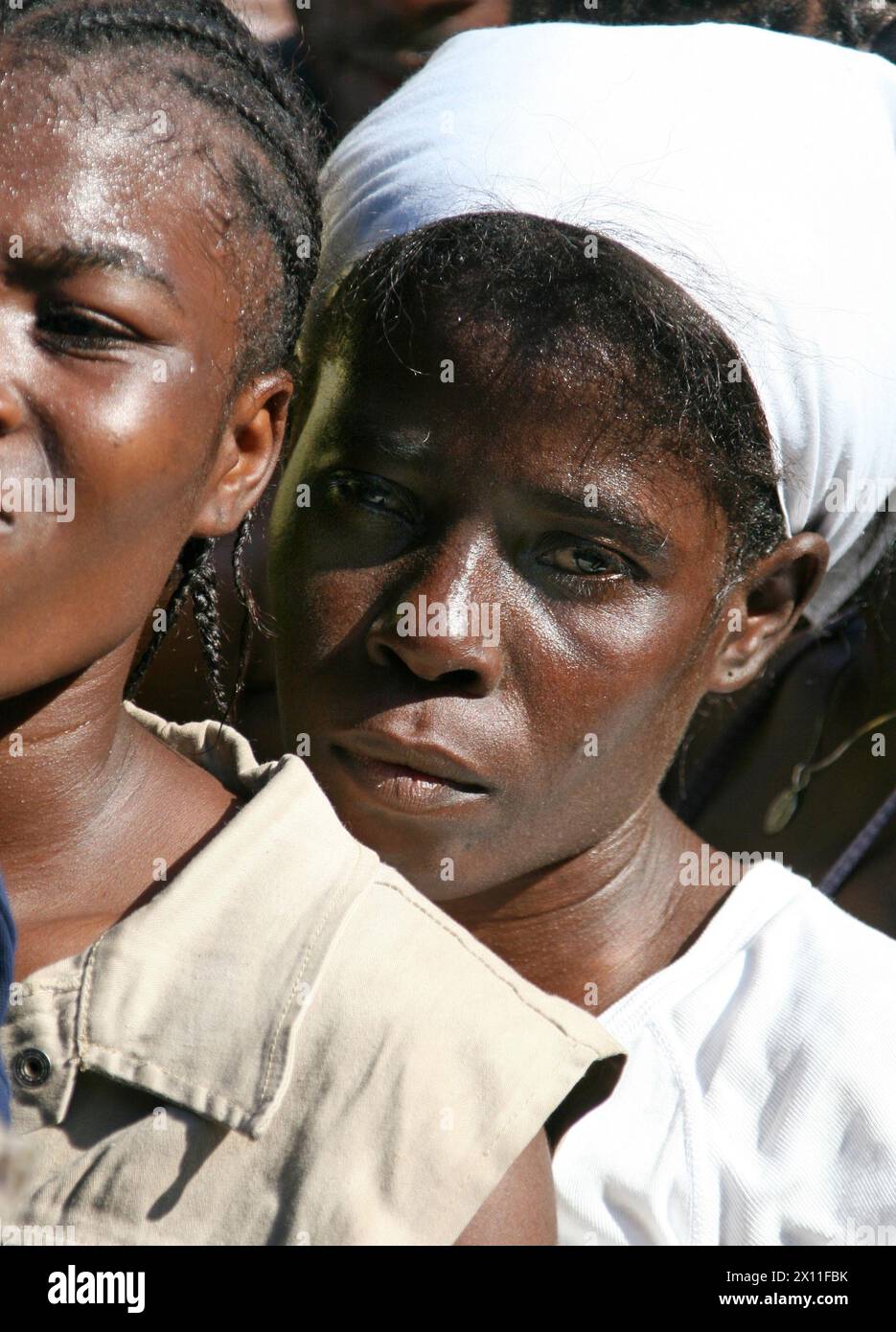 A Haitian woman stands in line at a distribution point set up by the ...