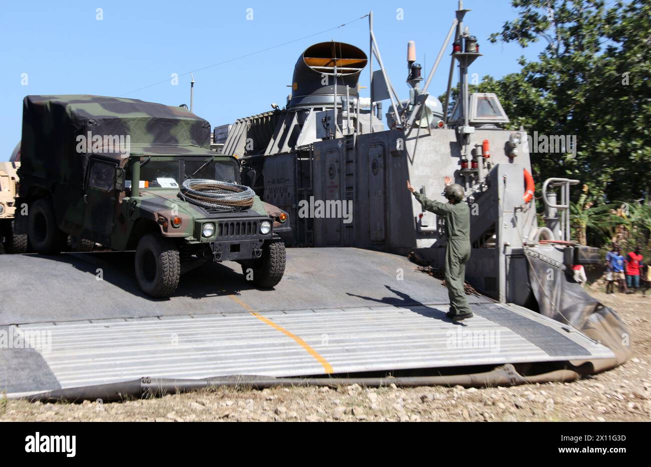 A Navy loadmaster from Assault Craft Unit 4 guides a 22nd Marine ...