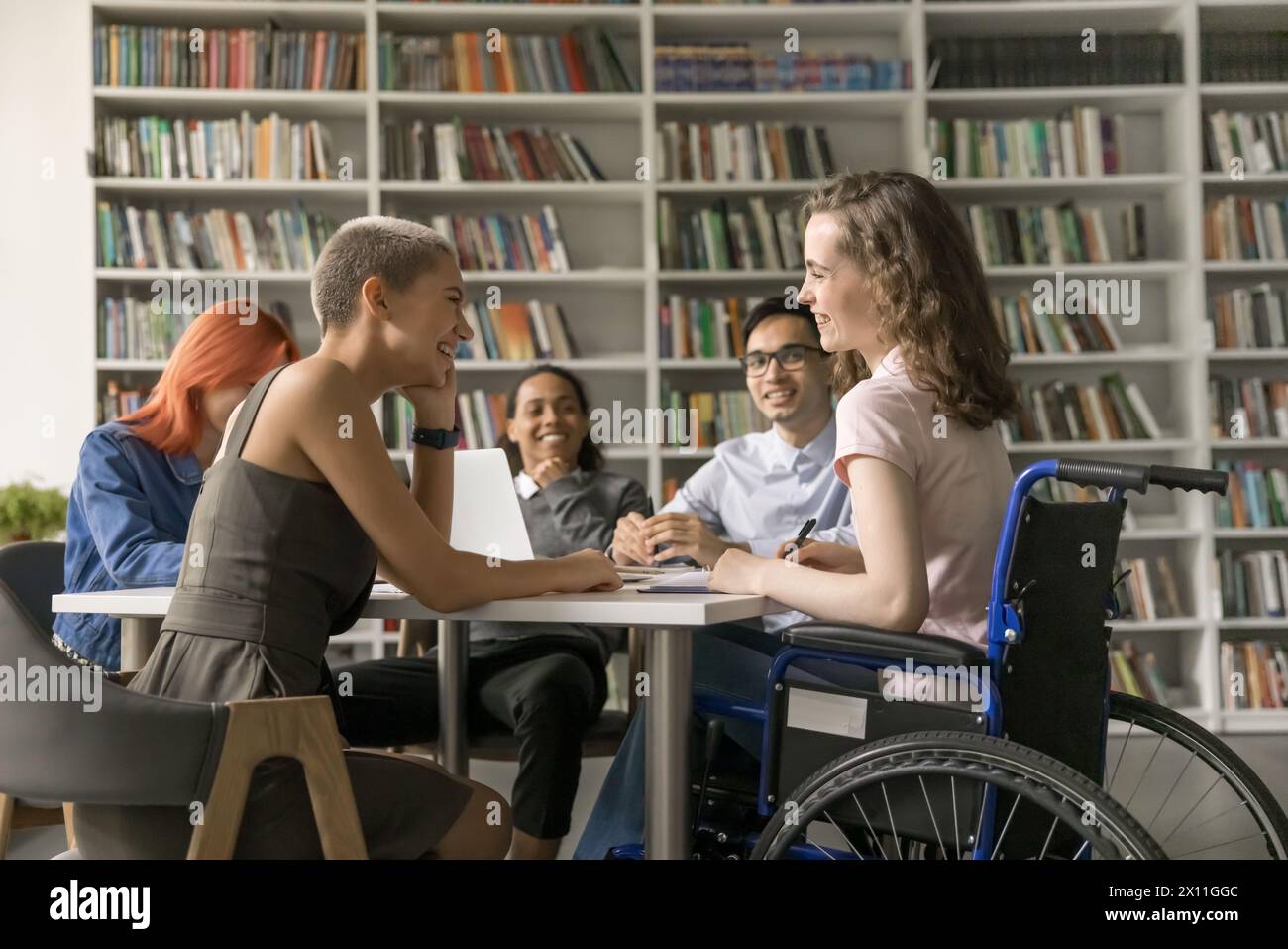 Group of students and girl with disability engaged in teamwork Stock ...