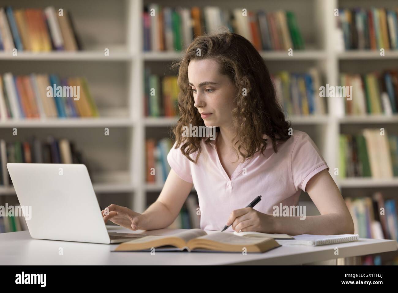 Student studying on-line, take notes, writing essay using laptop Stock ...