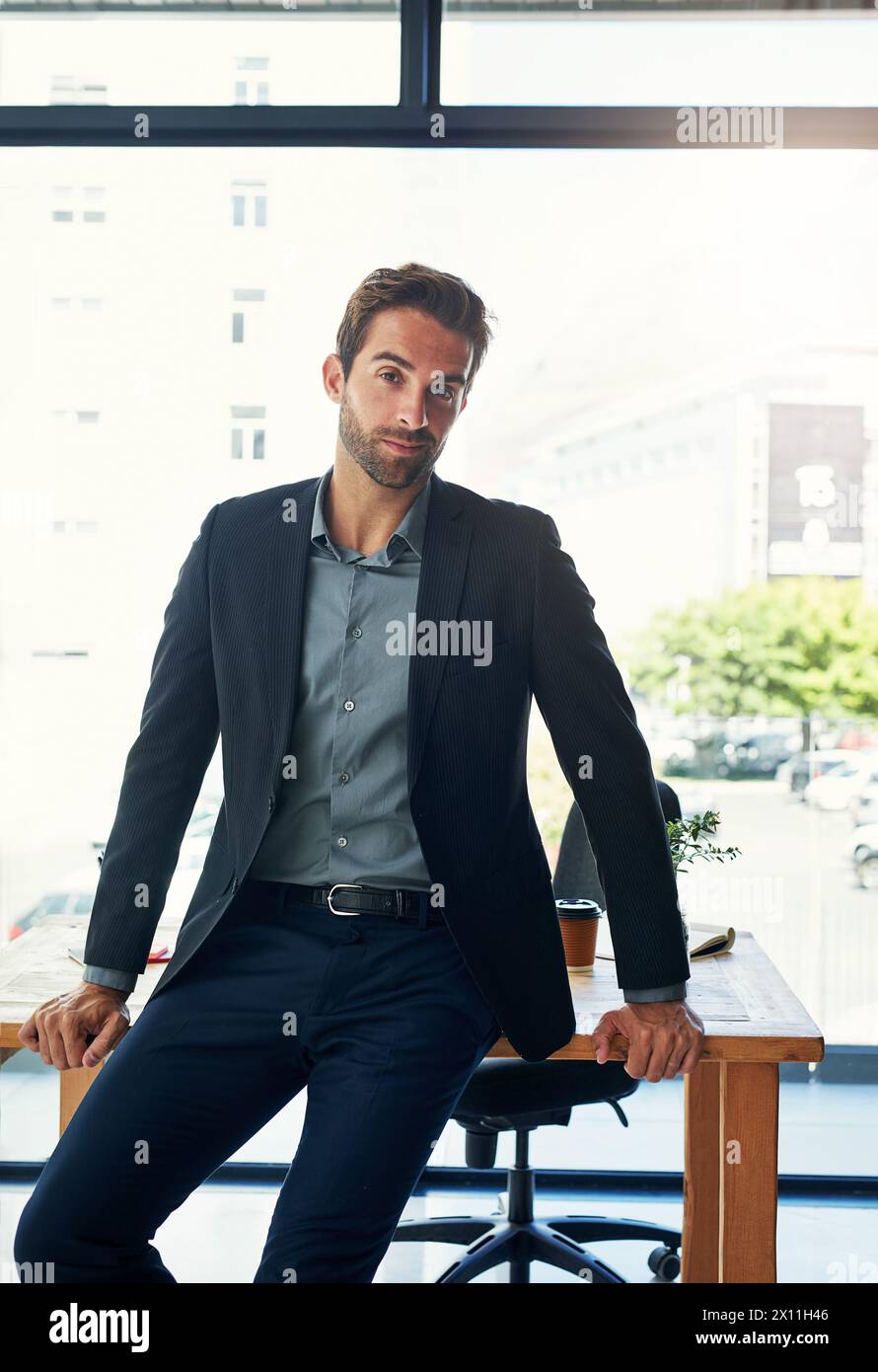 Portrait, business and man lean on desk in modern office with city view ...