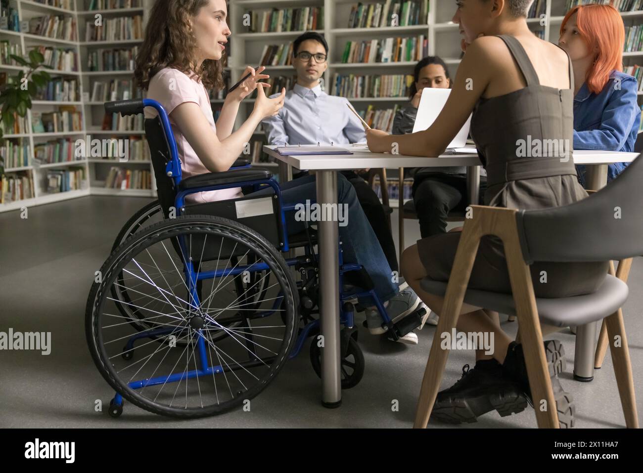 Serious diverse students involved in teamwork in library Stock Photo ...