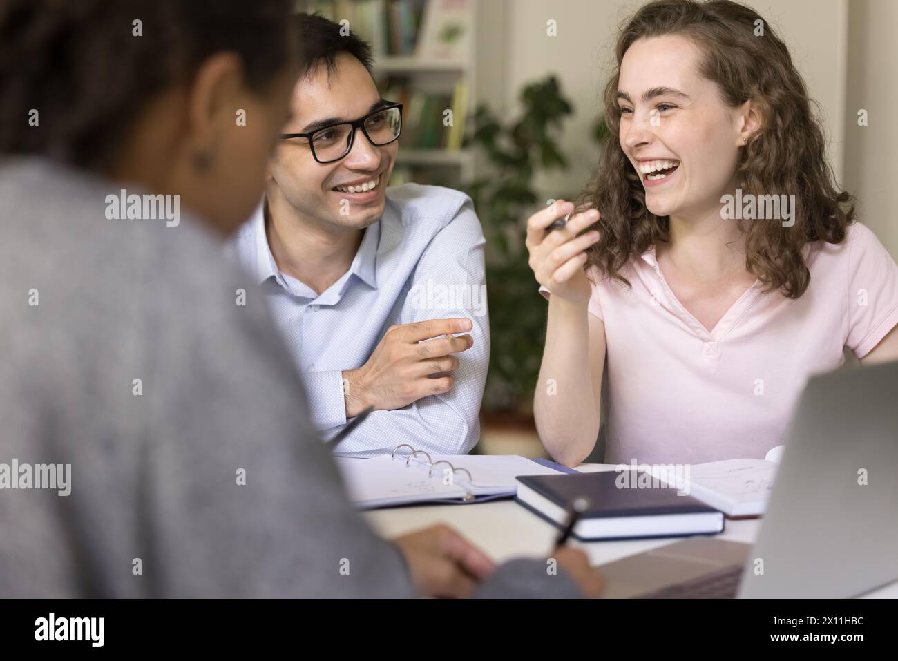 Interracial students studying together, joking, laughing met in ...
