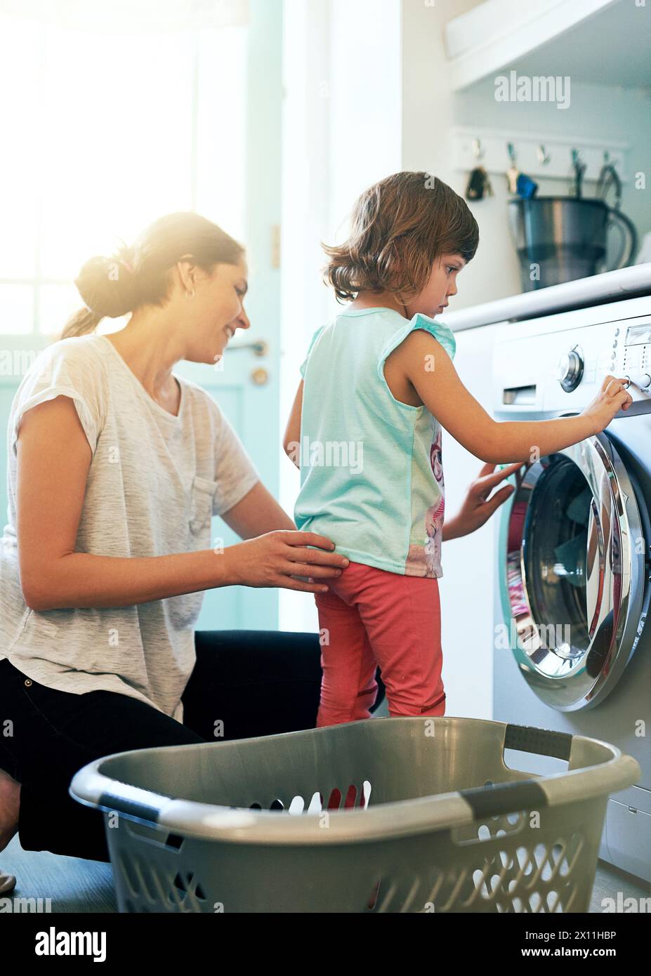 Help, laundry and mom with kid at washing machine for chores, teaching ...
