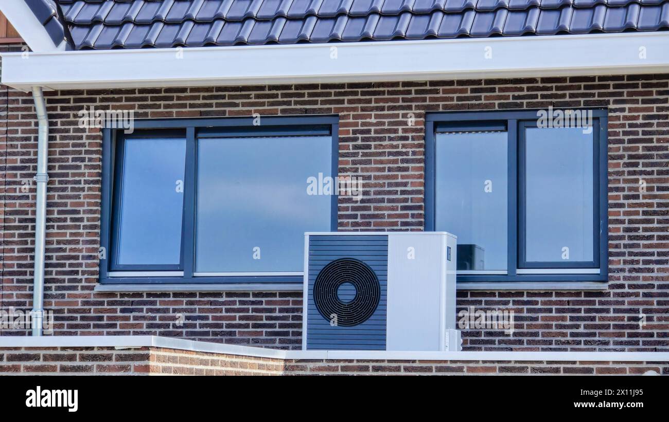 air source heat pump unit installed outdoors at a modern home with ...