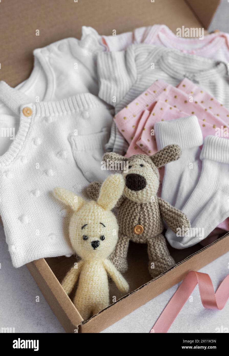 Baby and child clothes and knitted toys in carton box. Donation ...