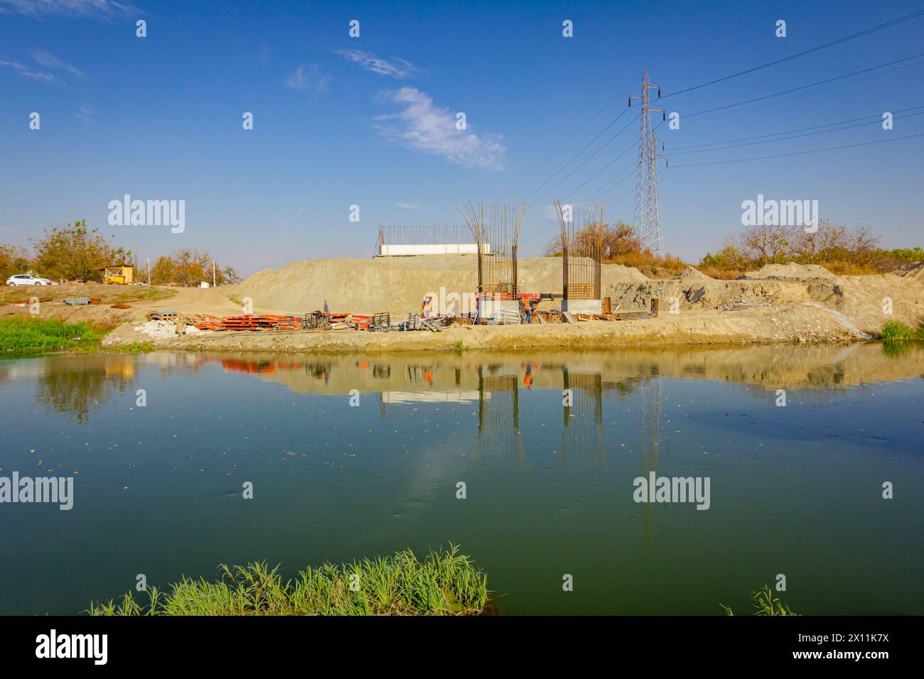 Reinforced concrete bridge pillars under construction across the river ...
