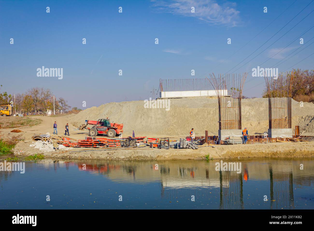 Reinforced concrete bridge pillars under construction across the river ...