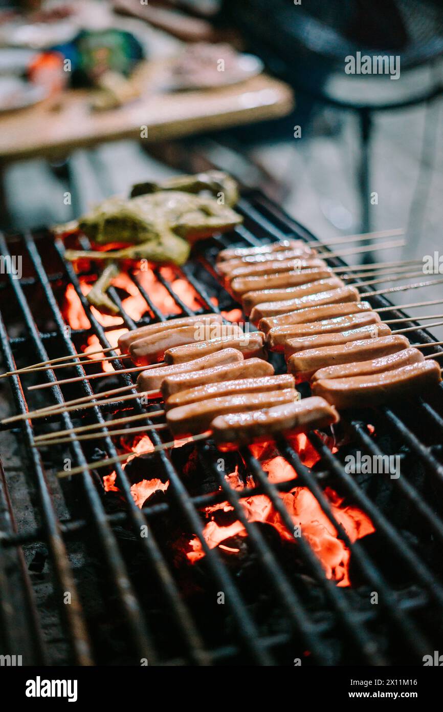 Grilled sausages skewered on skewers are prepared to be grilled on a ...