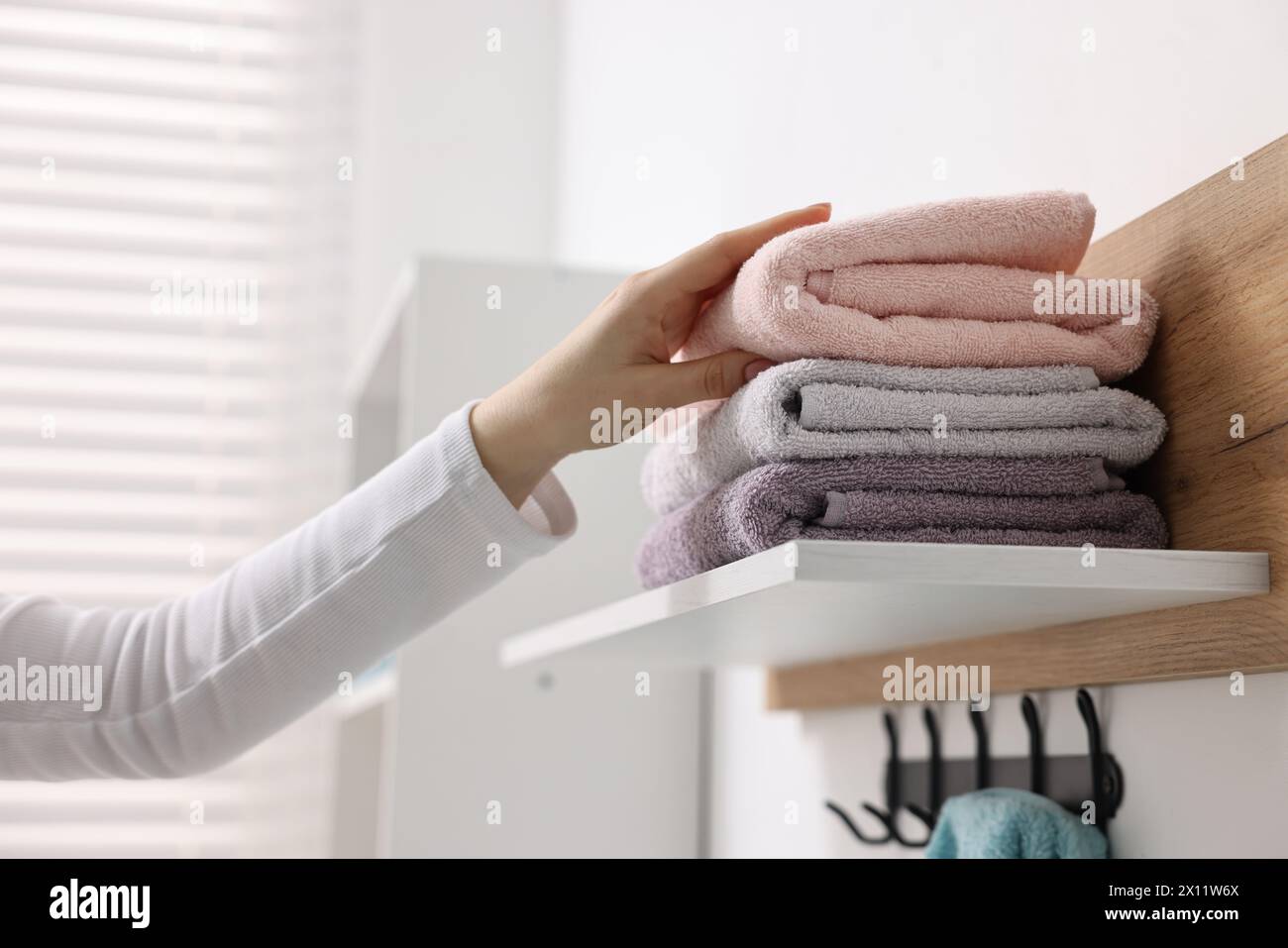 Woman stacking clean towels hi-res stock photography and images - Alamy