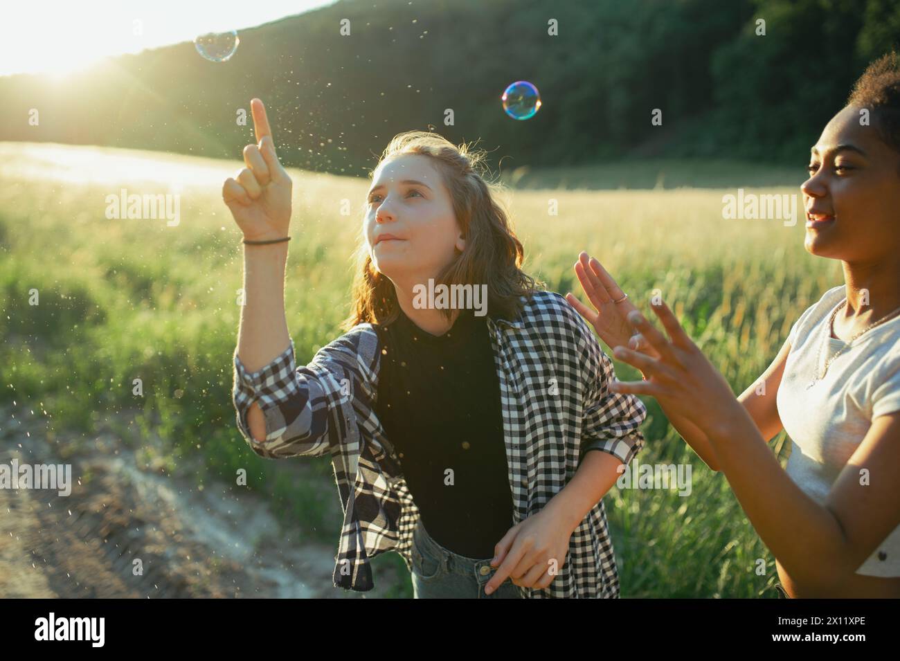 Young teenager girl best friends spending time in nature, during sunset ...
