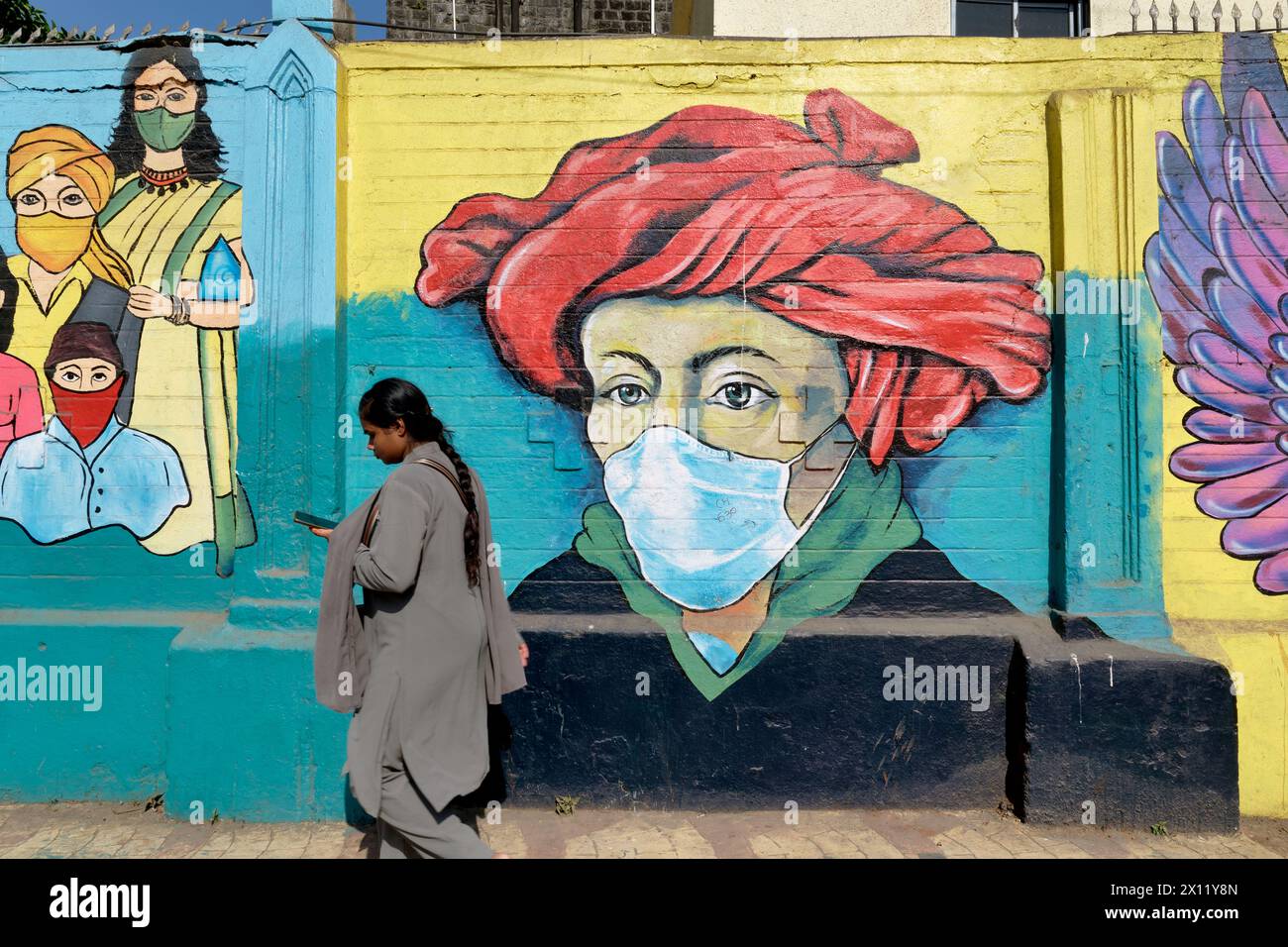 An Indian woman in the Byculla area, Mumbai, India, passes colorful ...
