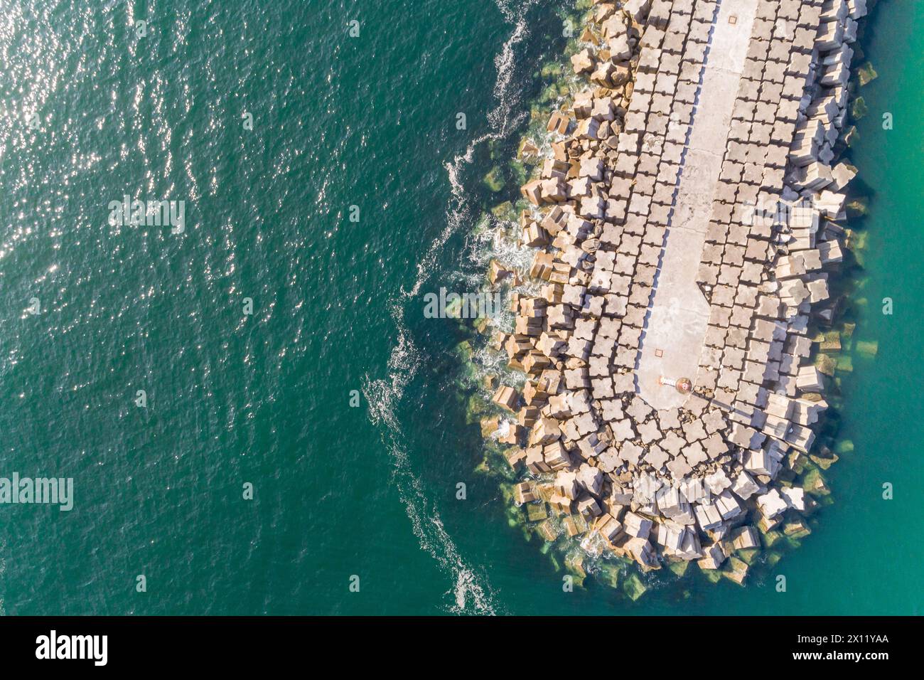 Top view with drone of a breakwater with large boulders jutting into ...