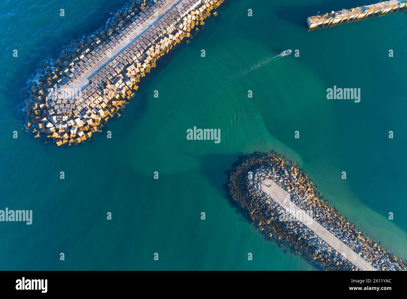 Aerial top view with drone of a fishing boat entering a harbor ...