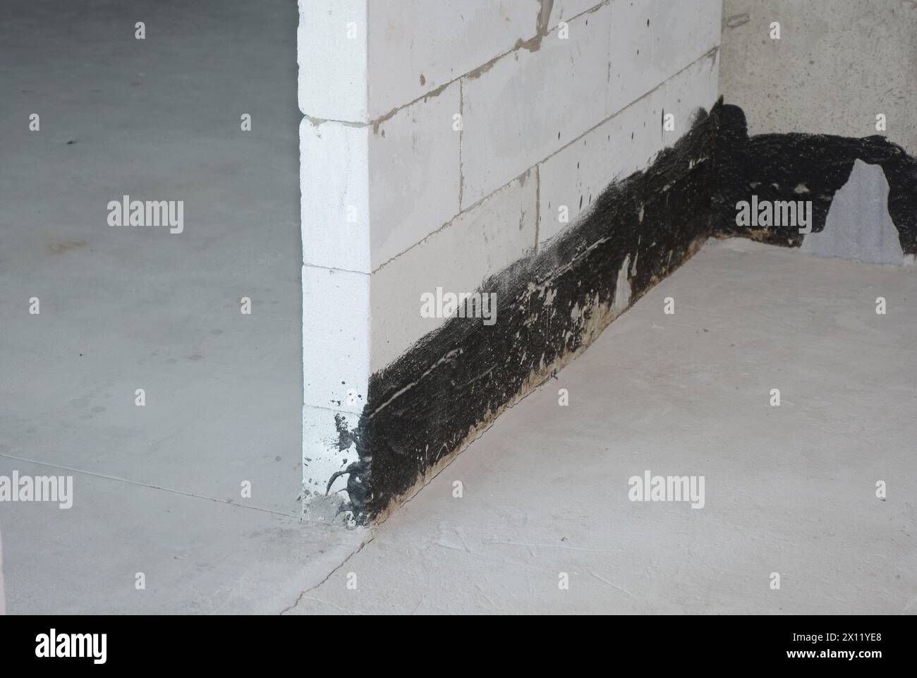 Close up on wall bitumen waterproofing indoors Stock Photo - Alamy