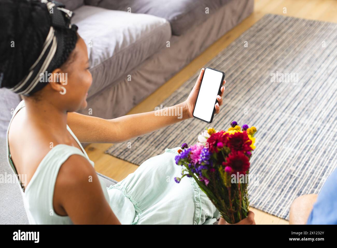 African American woman holding smartphone, showing screen on a video ...