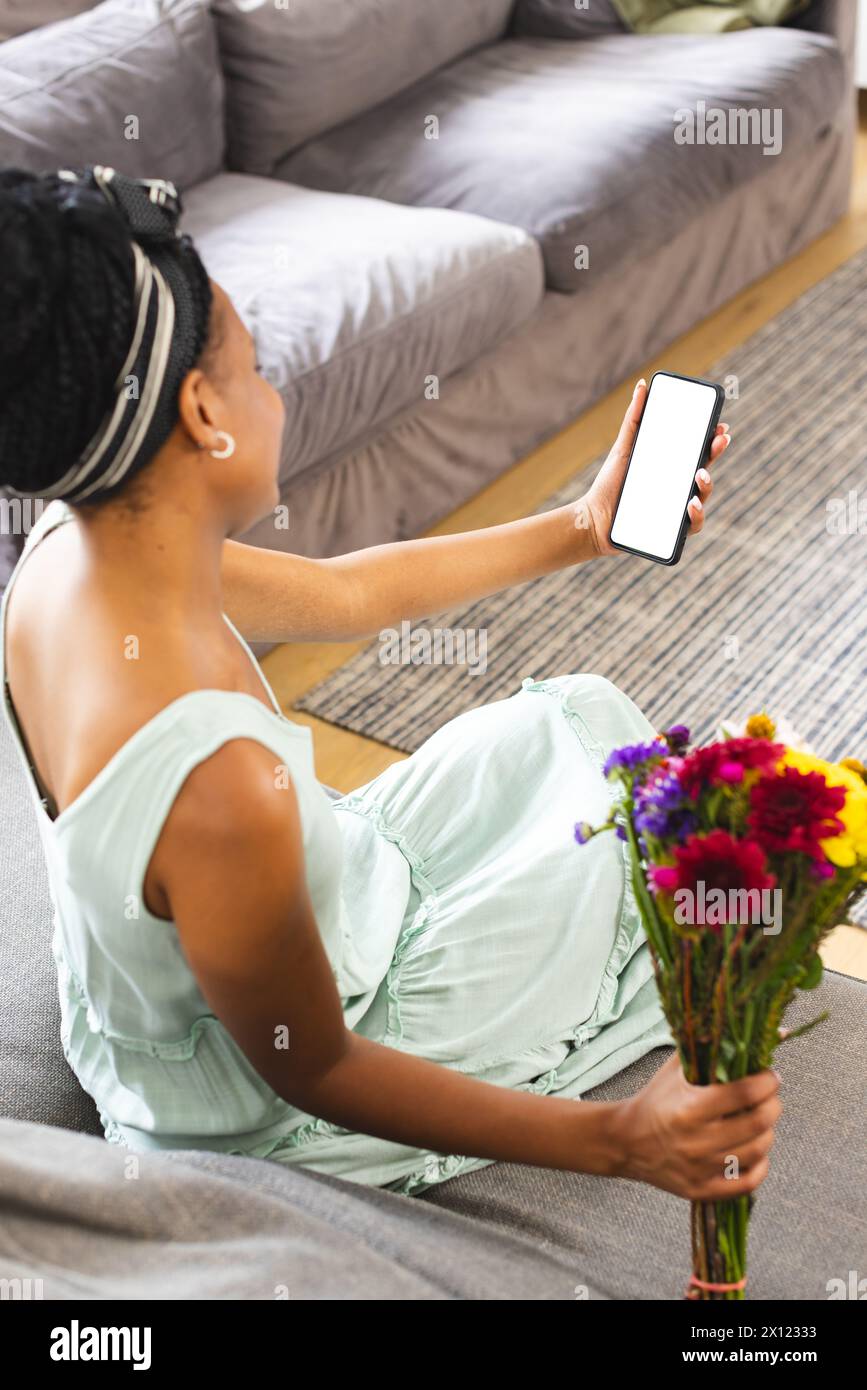 African American woman holding smartphone, showing screen on a video ...