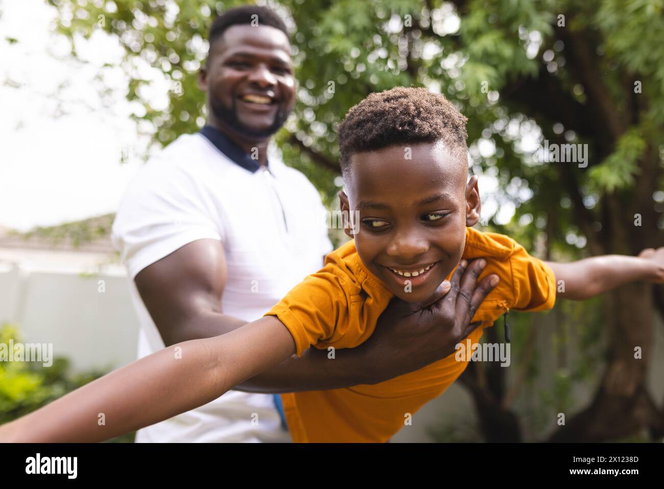 African American father and son are playing outside in the backyard at ...