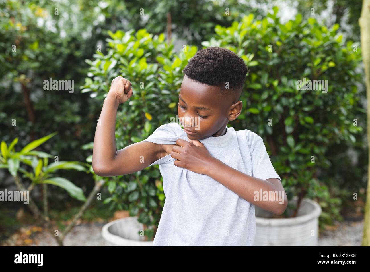 African American boy showing off muscles, in backyard at home Stock ...