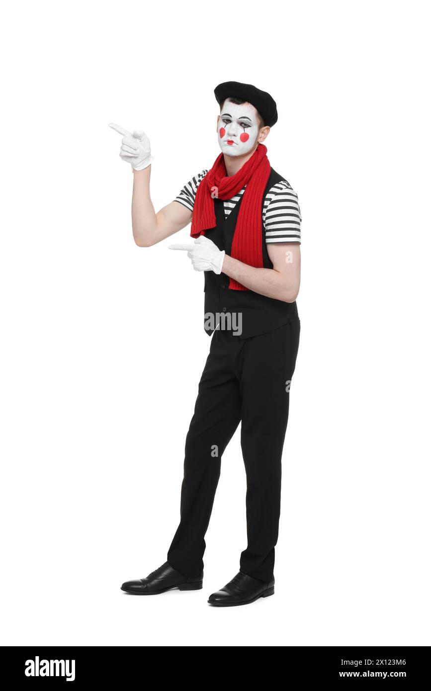 Funny mime artist in beret pointing at something on white background ...