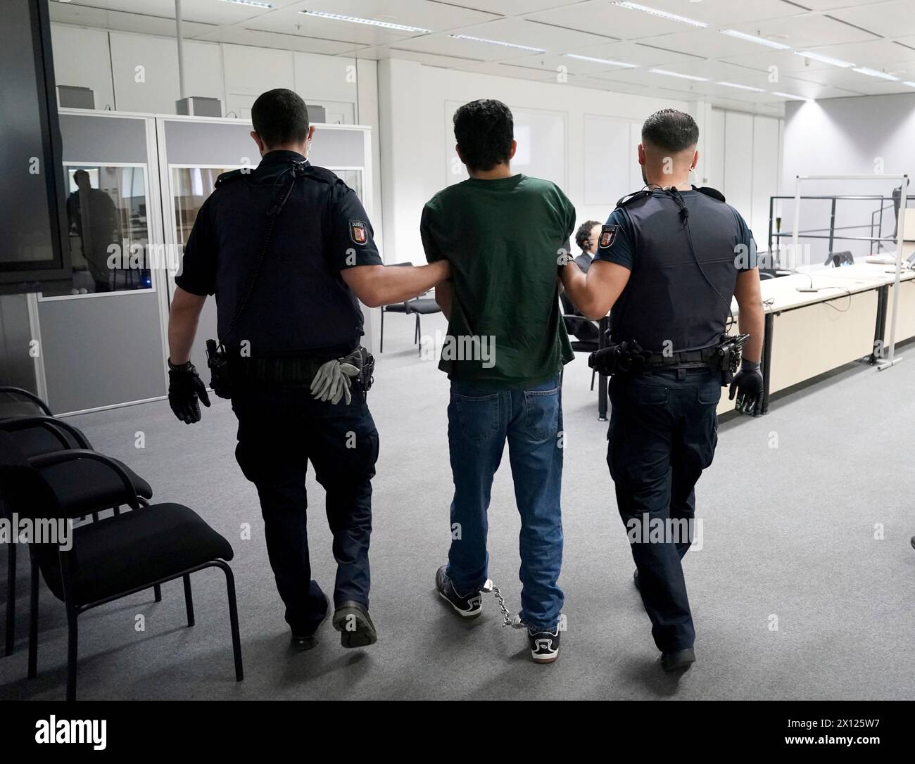 The defendant Ibrahim A. is brought into the courtroom in handcuffs, in ...
