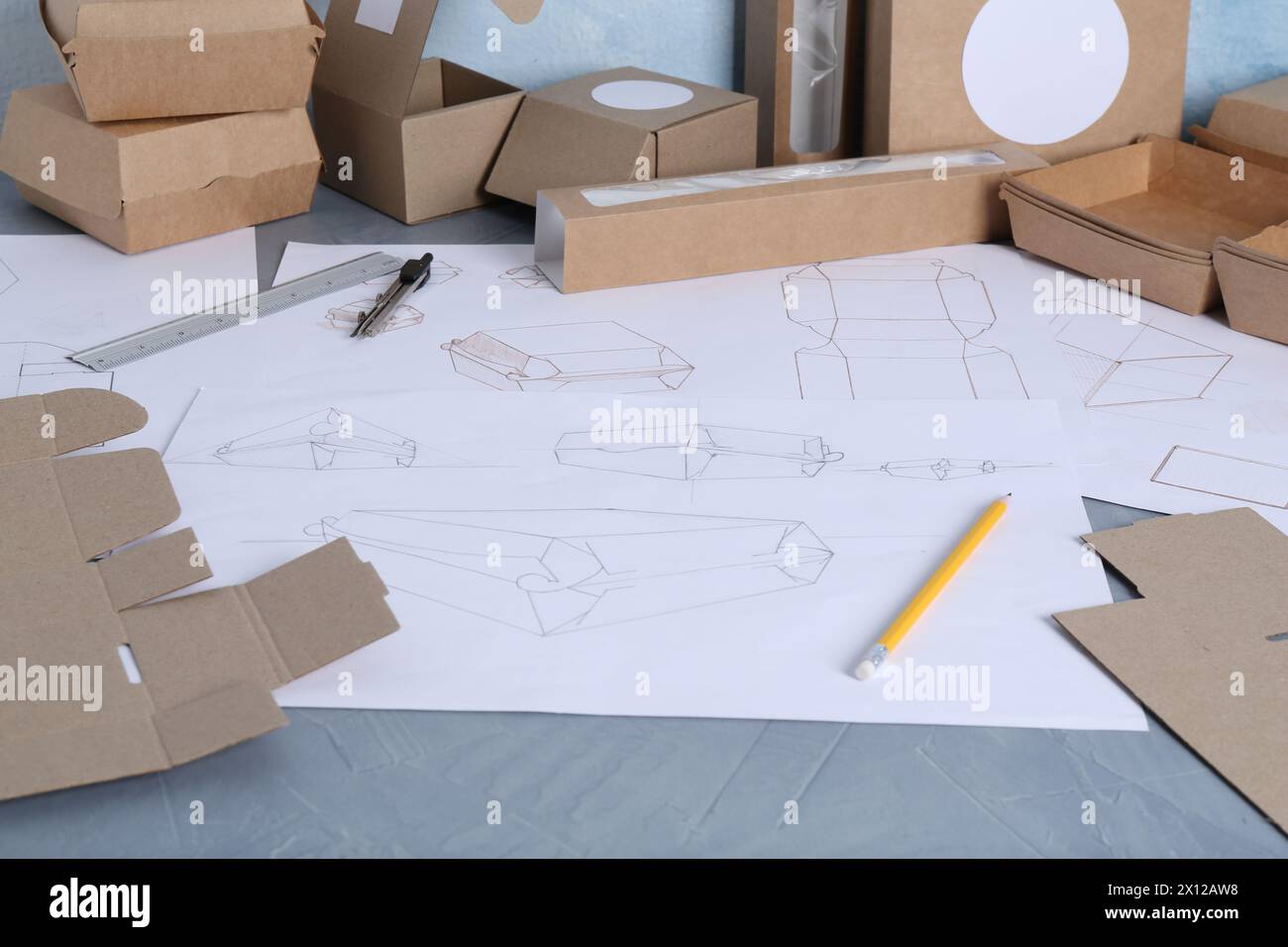 Creating packaging design. Drawings, boxes and stationery on blue ...