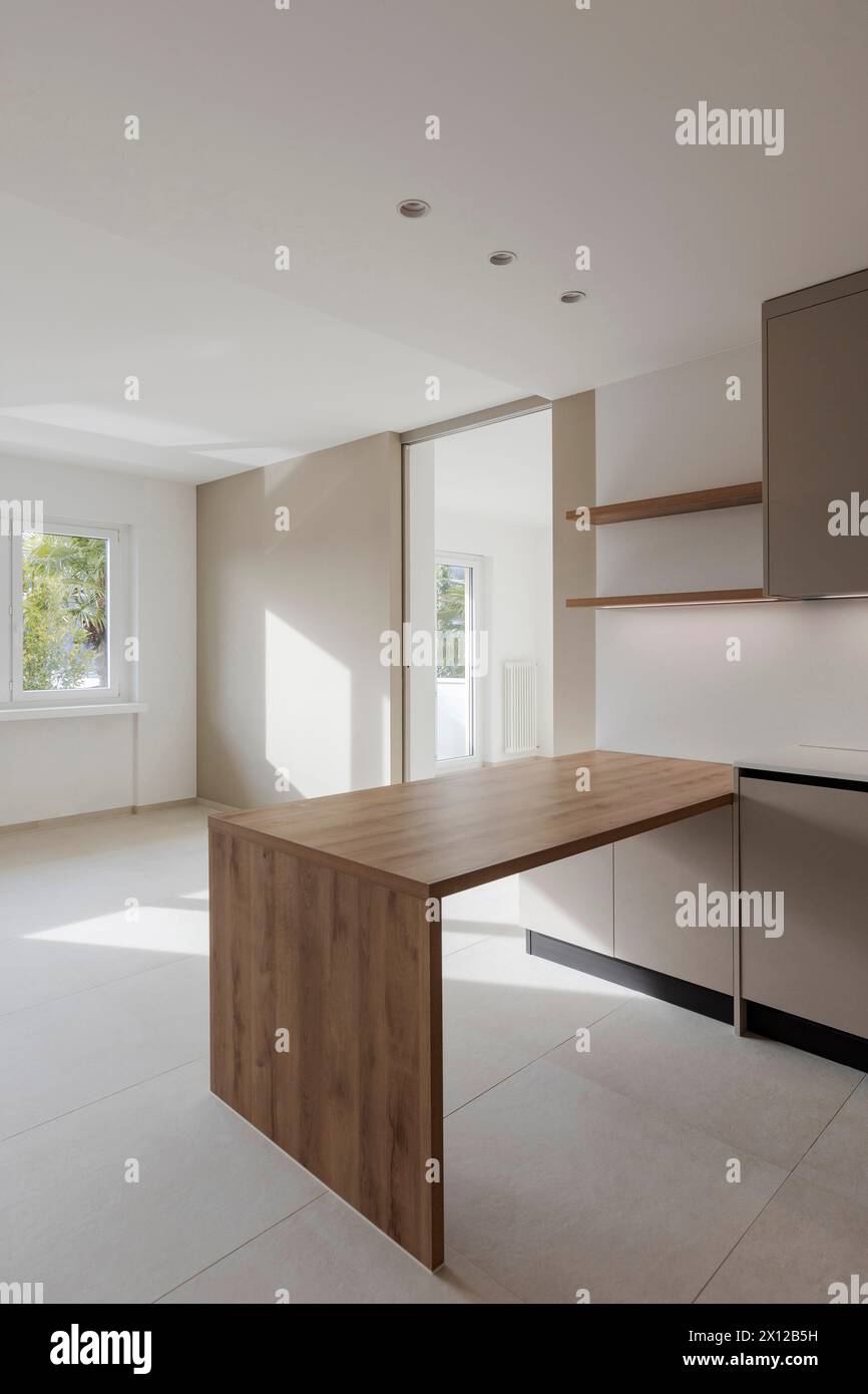 Wooden kitchen table attached to the wall. Behind asi sees an open door ...