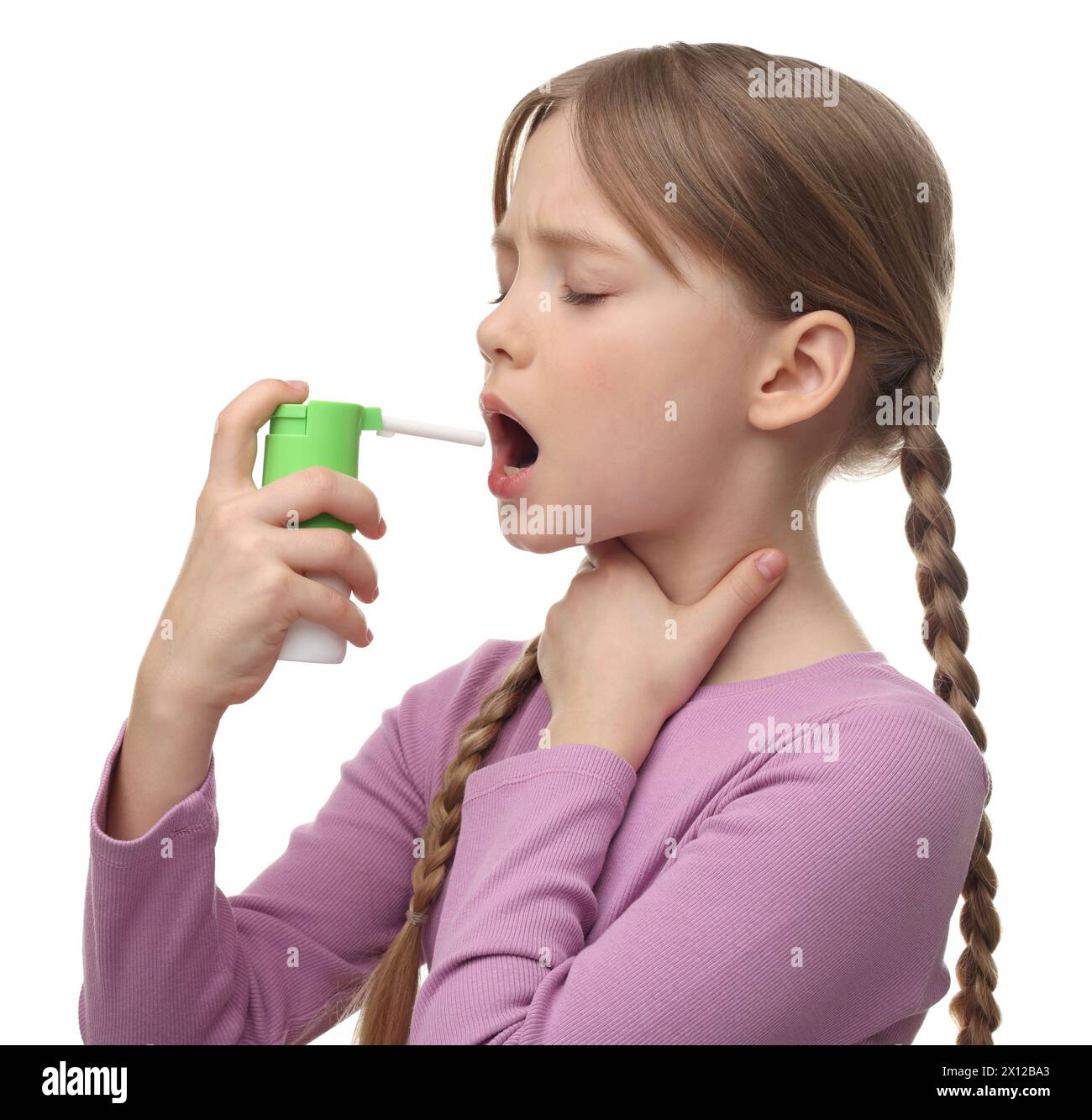 Little girl using throat spray on white background Stock Photo - Alamy