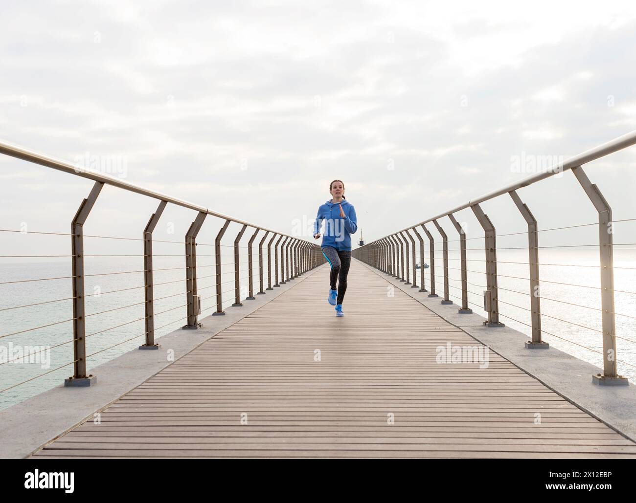 Front view of a fit woman running seaside on a promenade Stock Photo ...