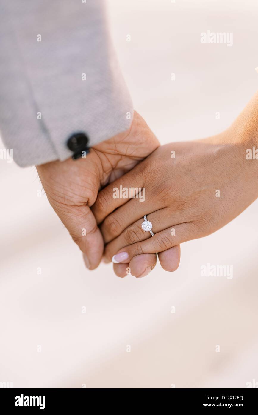 Couple holding hands with engagement ring Stock Photo - Alamy