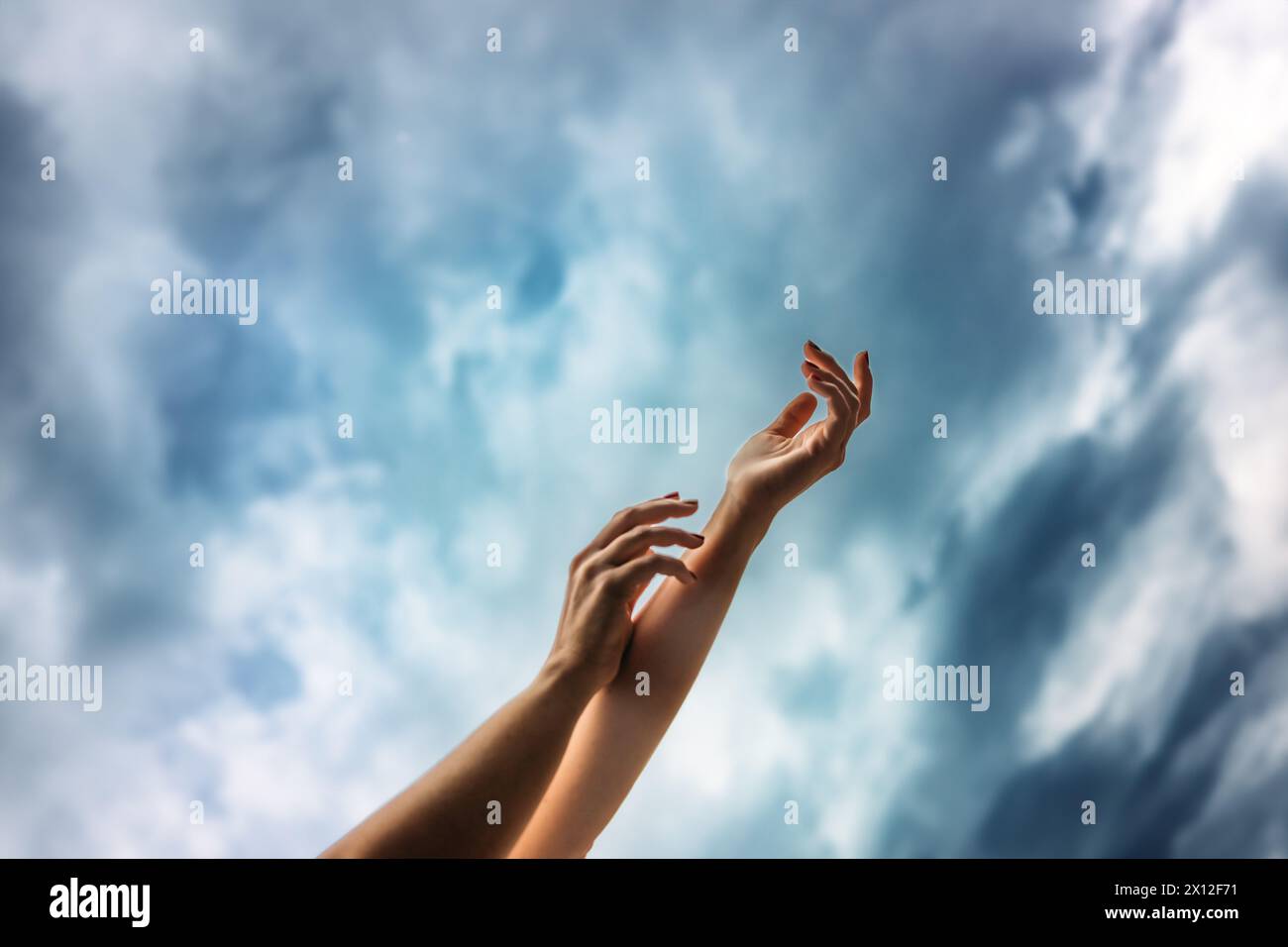 Woman’s hands reaching for the sky with clouds Stock Photo - Alamy
