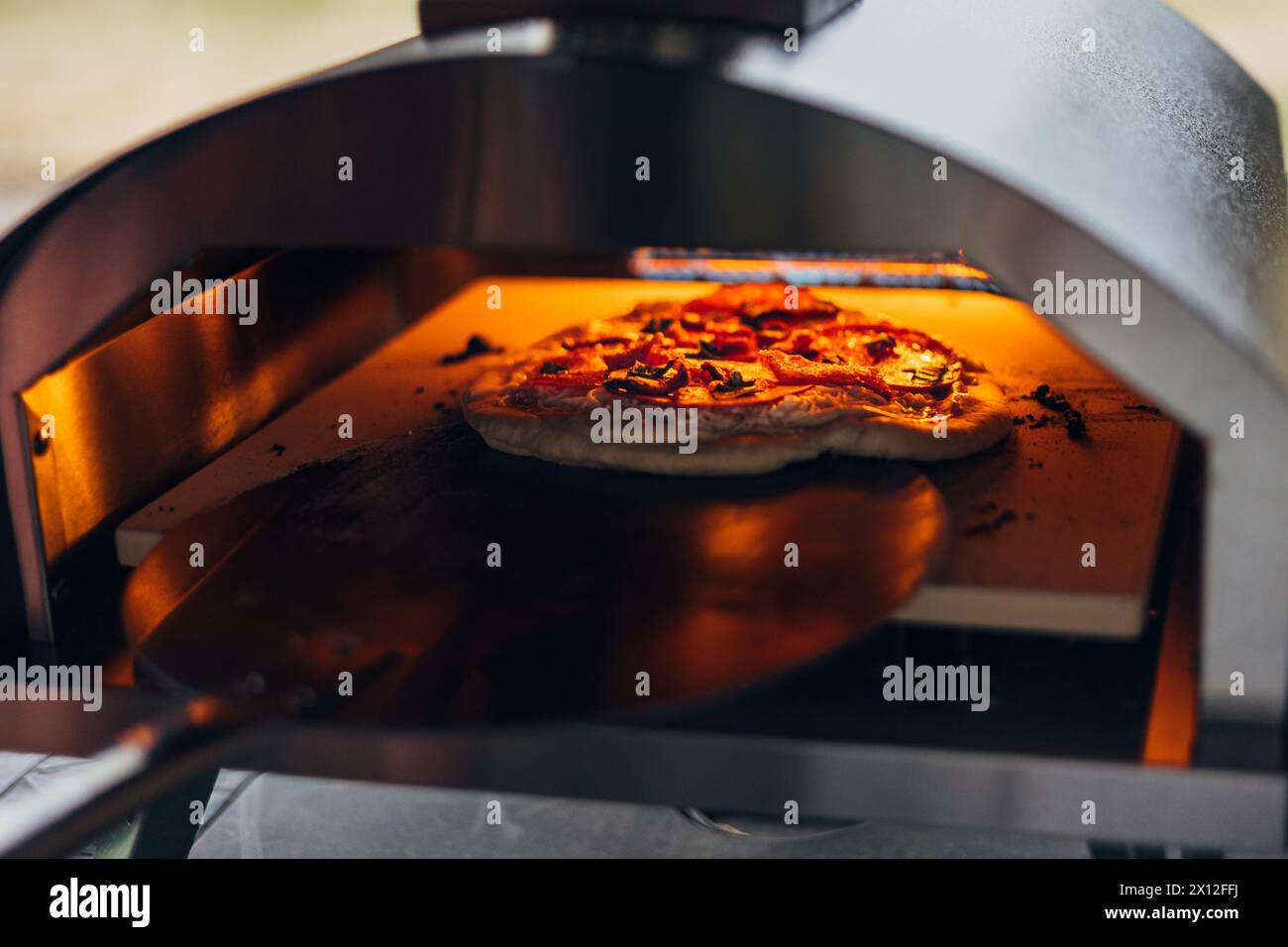 Pizza cooking in an outdoor pizza oven Stock Photo - Alamy