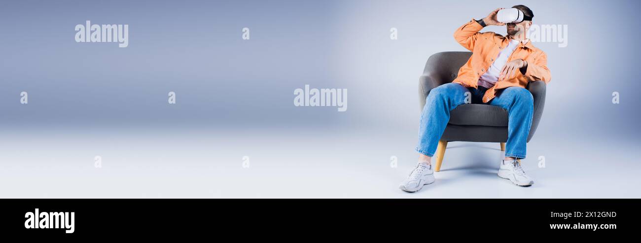 A man wearing a VR headset sits in a chair with his head in his hands ...