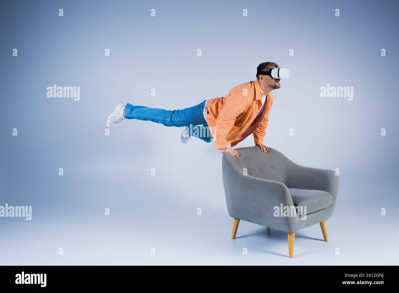A man in an orange shirt executes a mesmerizing trick on a chair in a ...