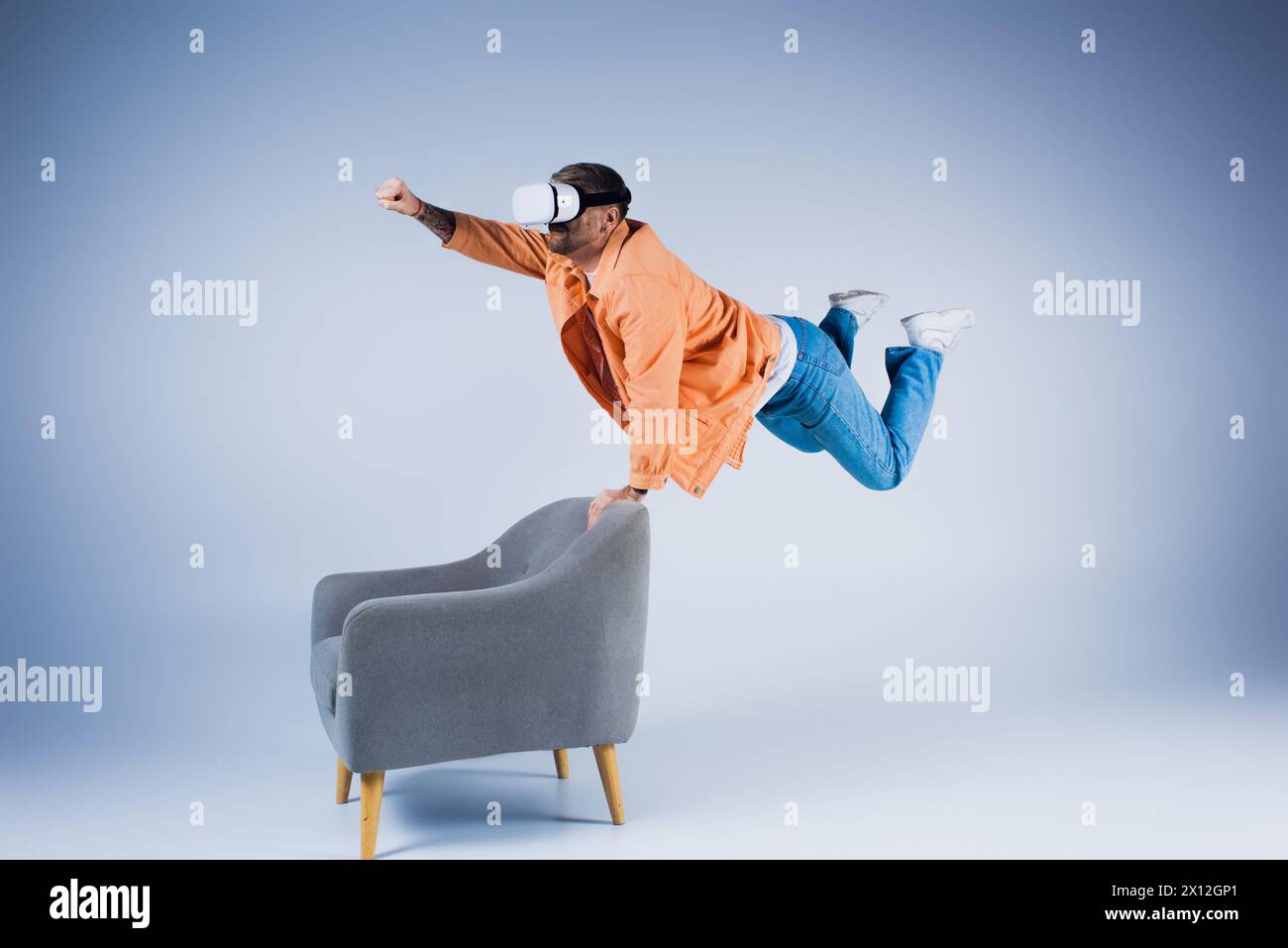 A man in an orange shirt showcasing a gravity-defying trick while ...