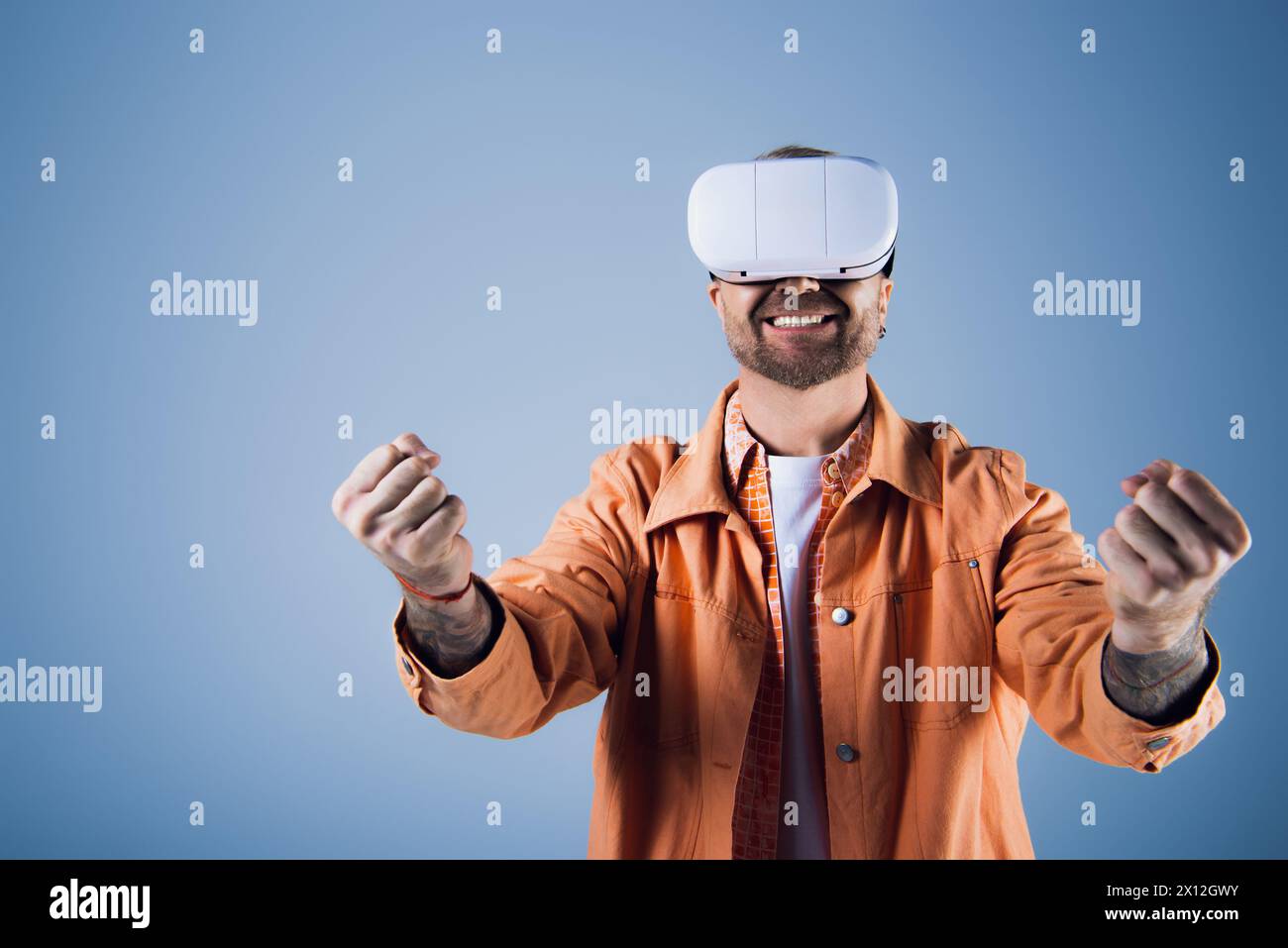 A man in an orange shirt and tie explores the virtual world with a VR ...