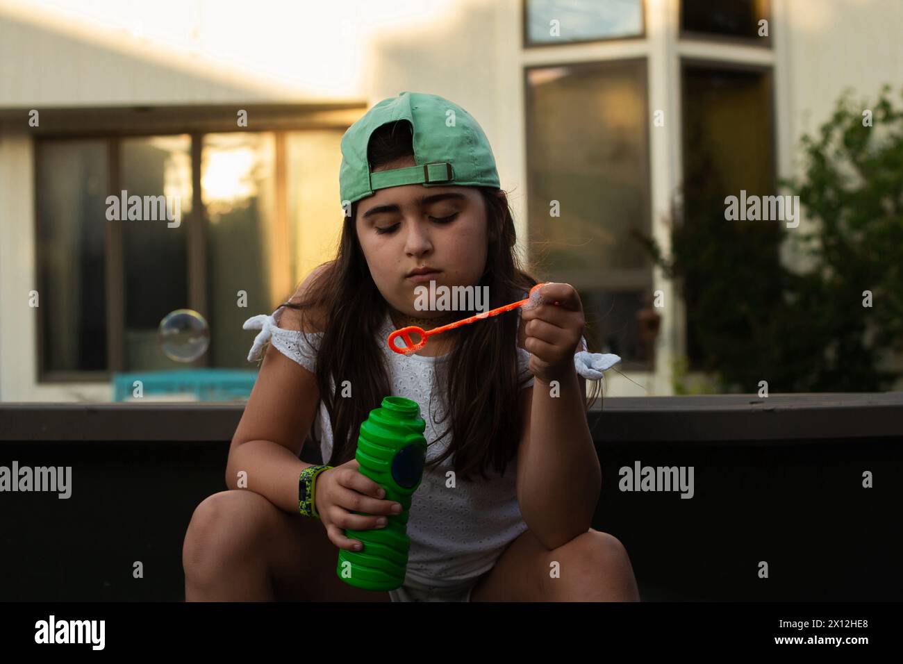 Girl blowing bubbles looking bored Stock Photo - Alamy