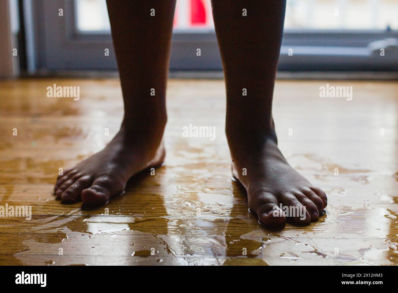 Wet feet on wood floor Stock Photo - Alamy