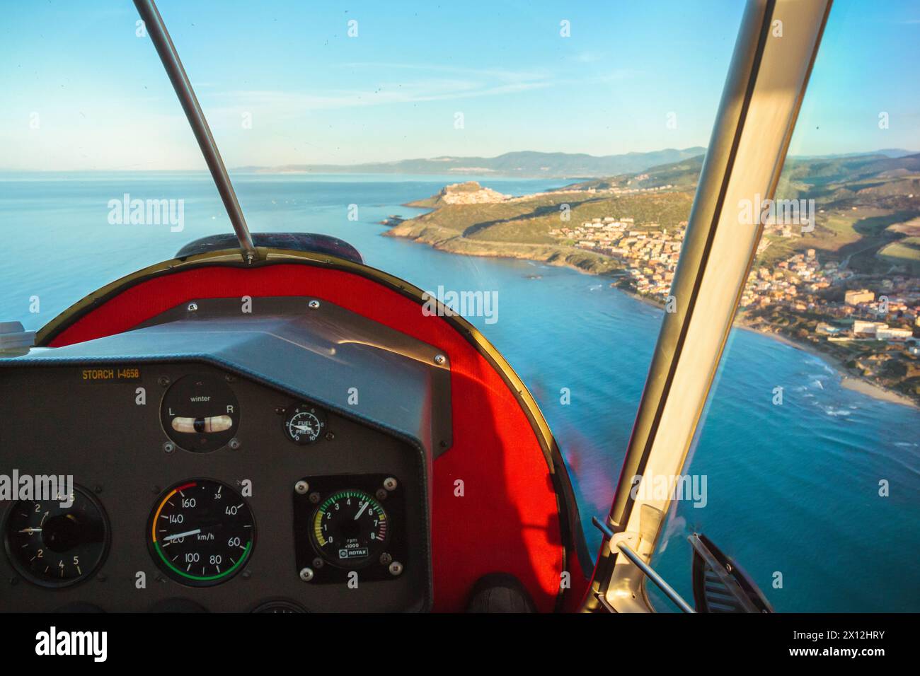 sunny sandy coastline viewed from the cockpit of a light tourist ...