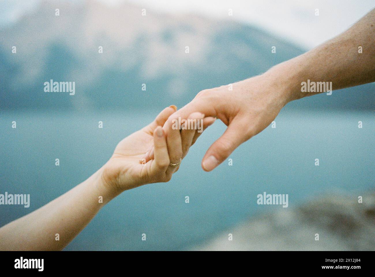 Hand Embrace Against Mountain Backdrop Stock Photo - Alamy