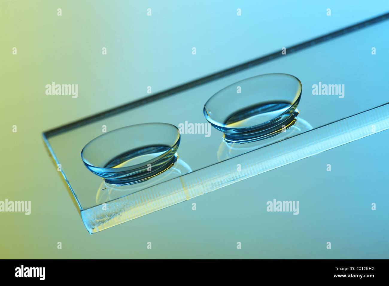 Pair of contact lenses on glass against color background, closeup Stock ...