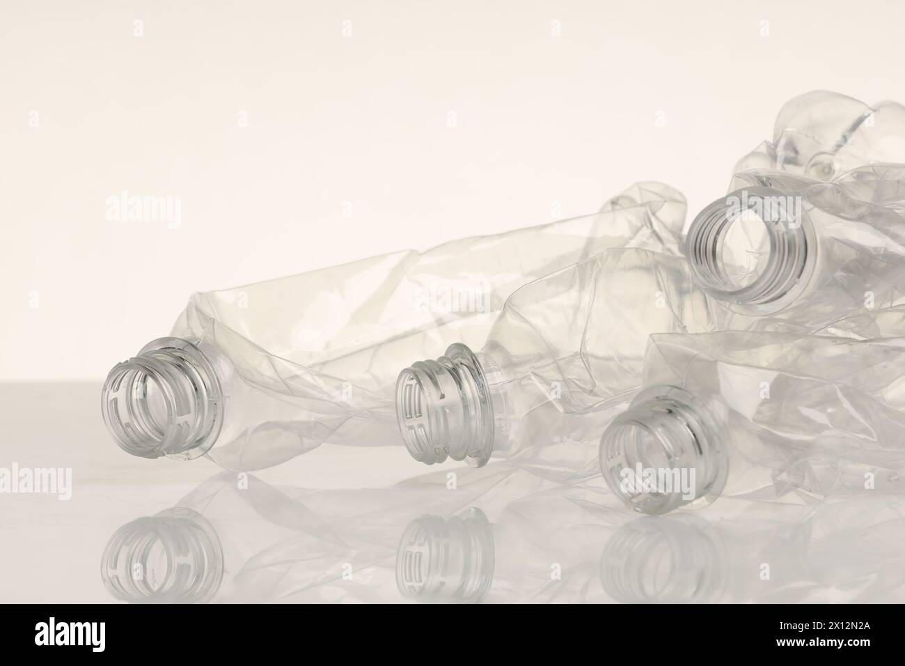 Crumpled disposable plastic bottles on white background Stock Photo - Alamy