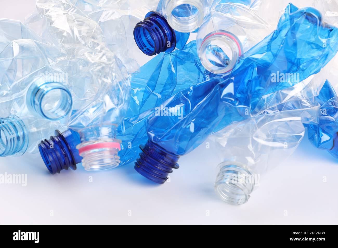 Crumpled disposable plastic bottles on white background Stock Photo - Alamy