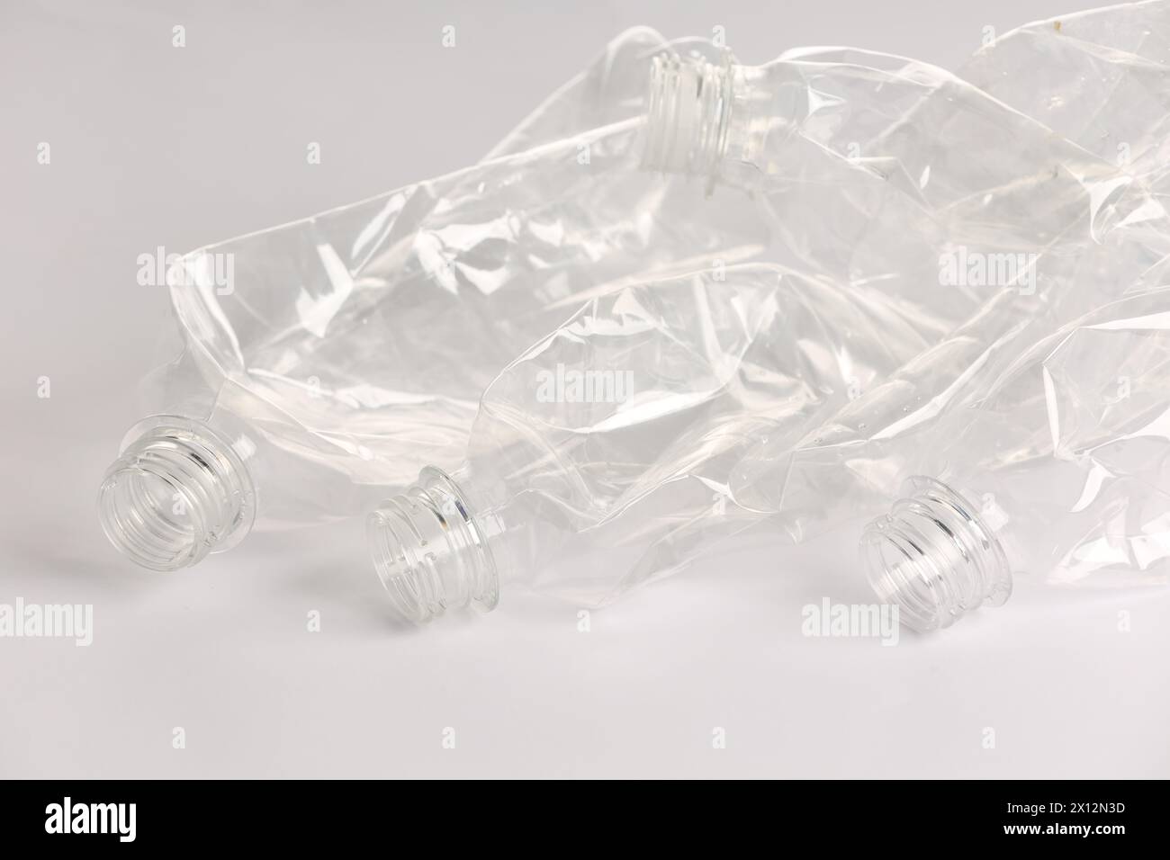 Crumpled disposable plastic bottles on white background Stock Photo - Alamy