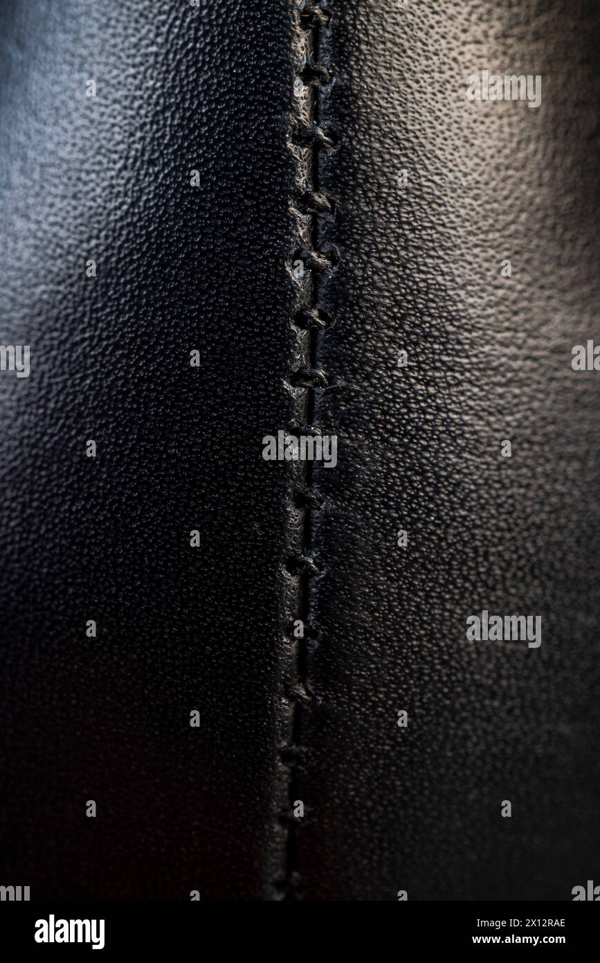 a black leather object sewn from several parts, part of a shoe made of ...