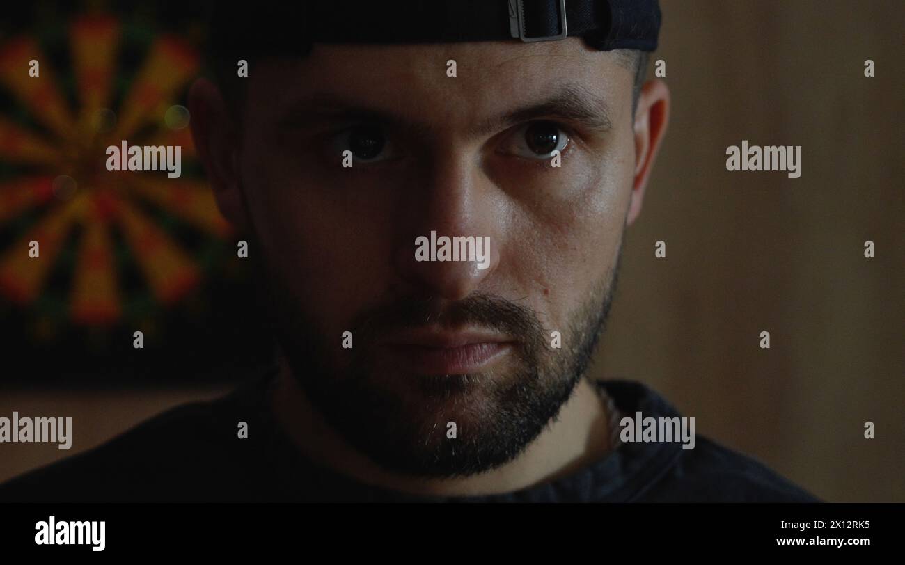 Close-up portrait of a brutal man looking intently and cautiously at ...