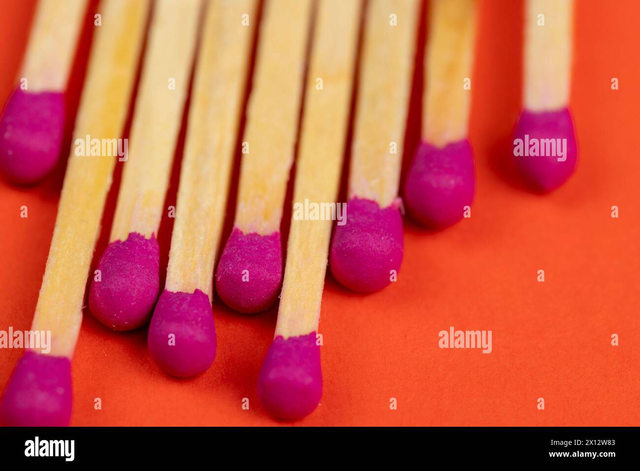 long wooden matches on a paper background, matches with a red pink ...