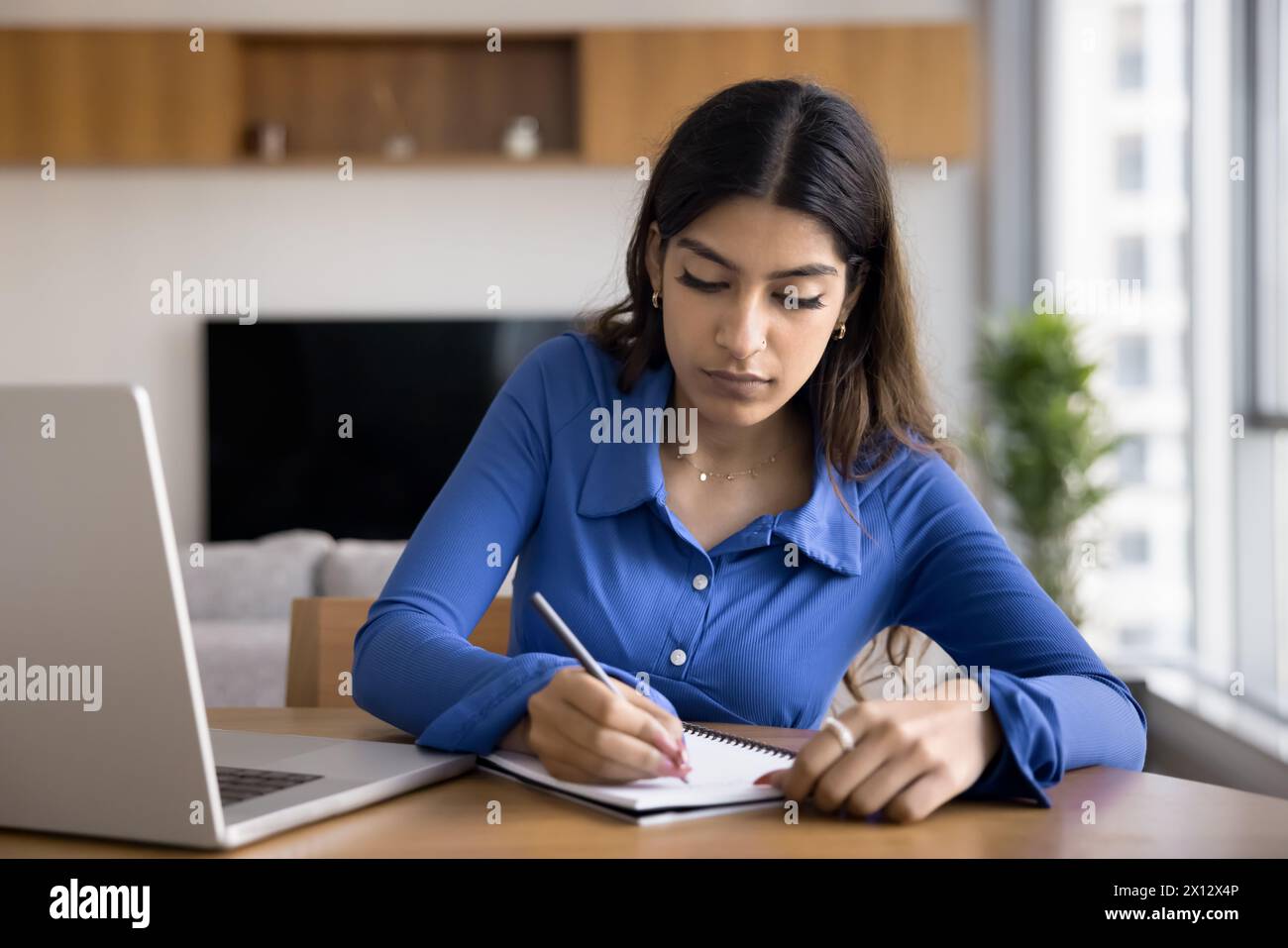 Focused young Indian student girl writing notes at laptop Stock Photo ...